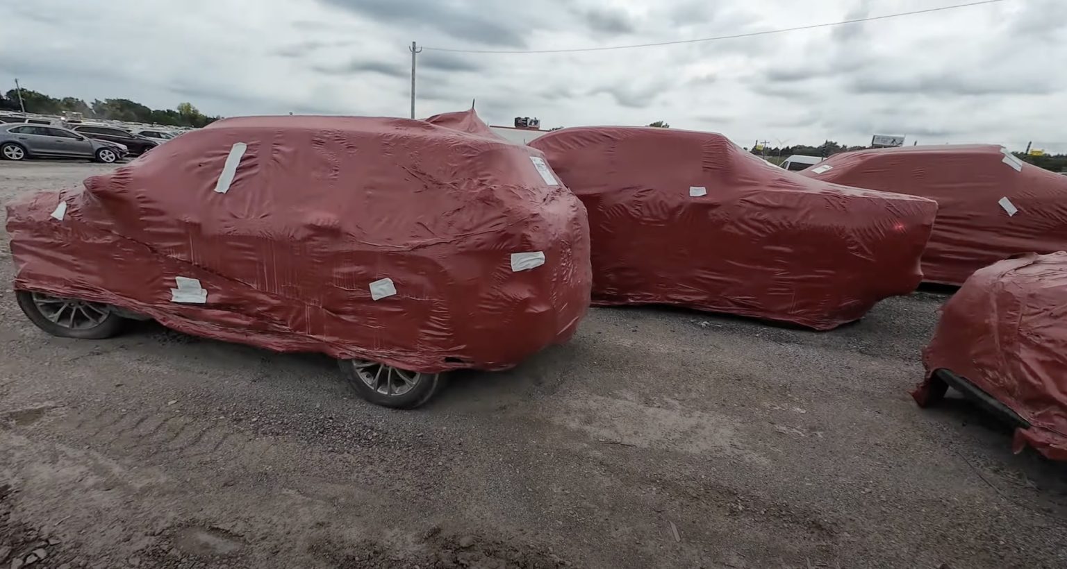 Wrecked Vehicles Cloaked in Red Plastic Await Fate at Insurance Auto ...